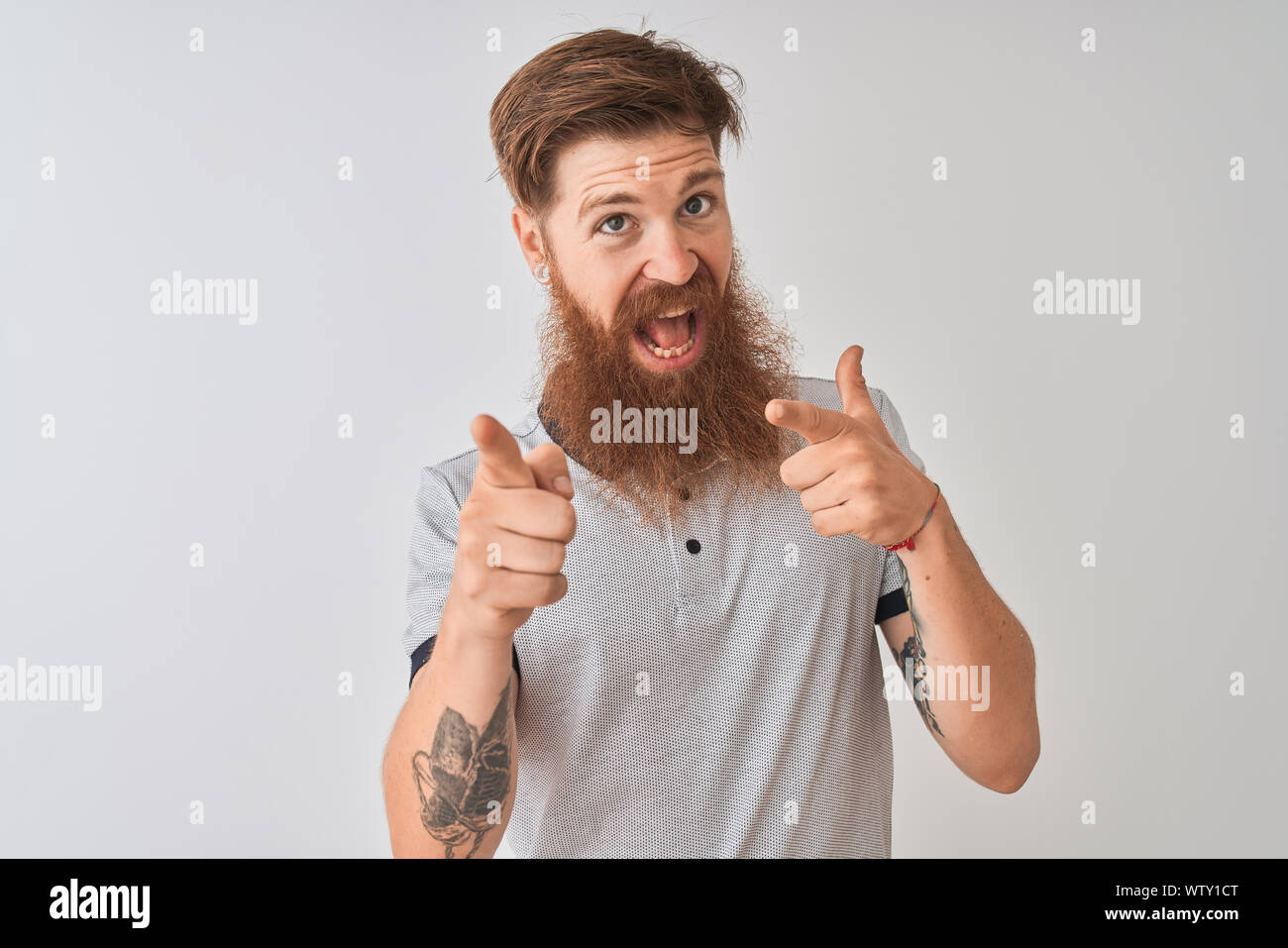 Young redhead irish man wearing grey polo standing over isolated white ...