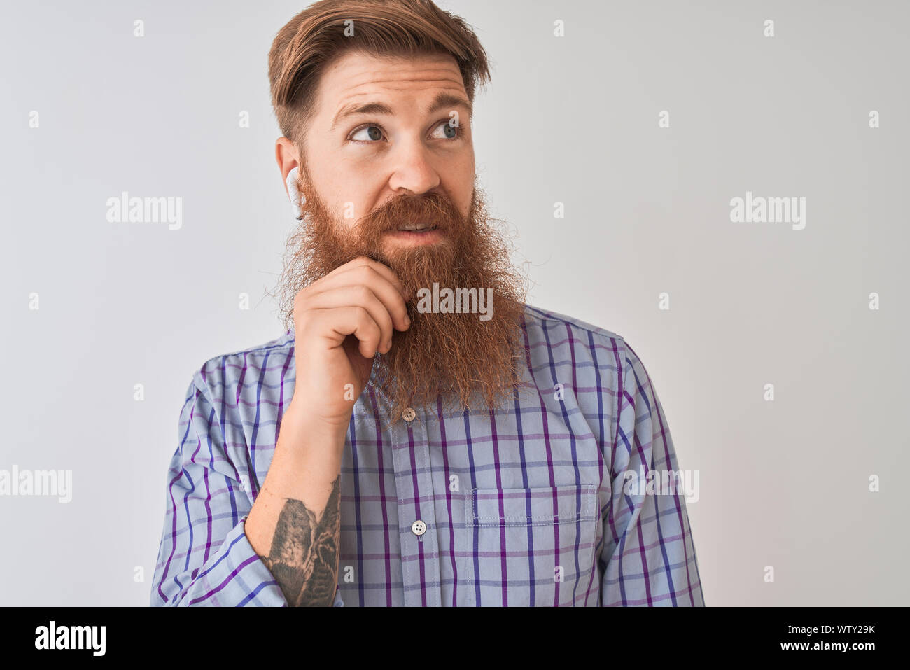 Redhead irish man listening to music using wireless earphones over ...