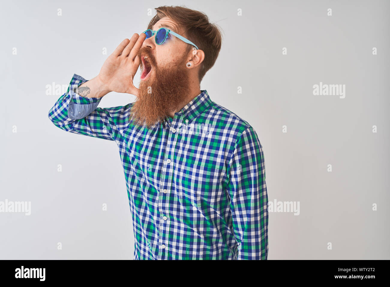 Young redhead irish man wearing casual shirt and sunglasses over ...