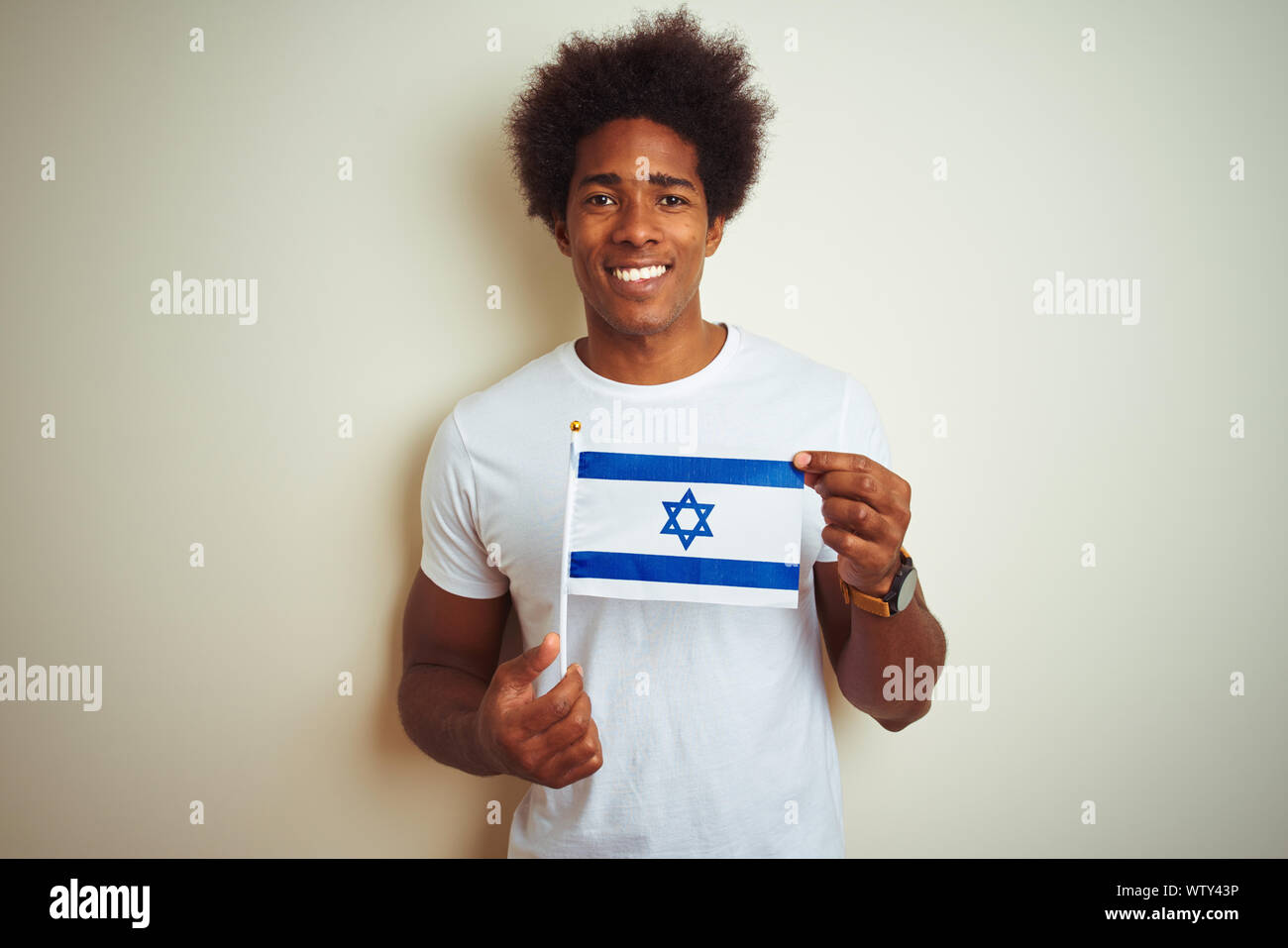 Young african american man holding Israel Israeli flag standing over ...