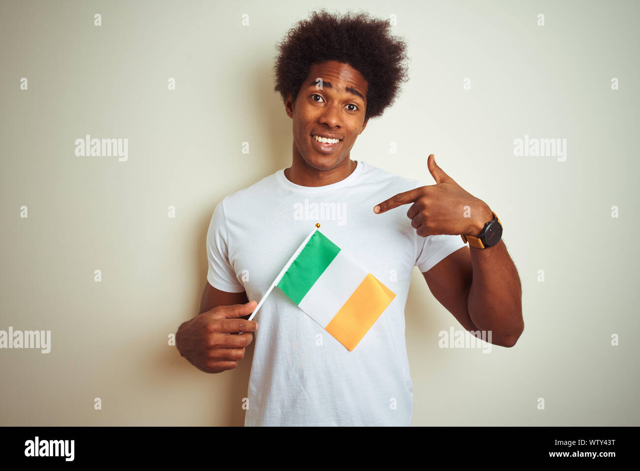 Young african american man holding Ireland Irish flag standing over ...