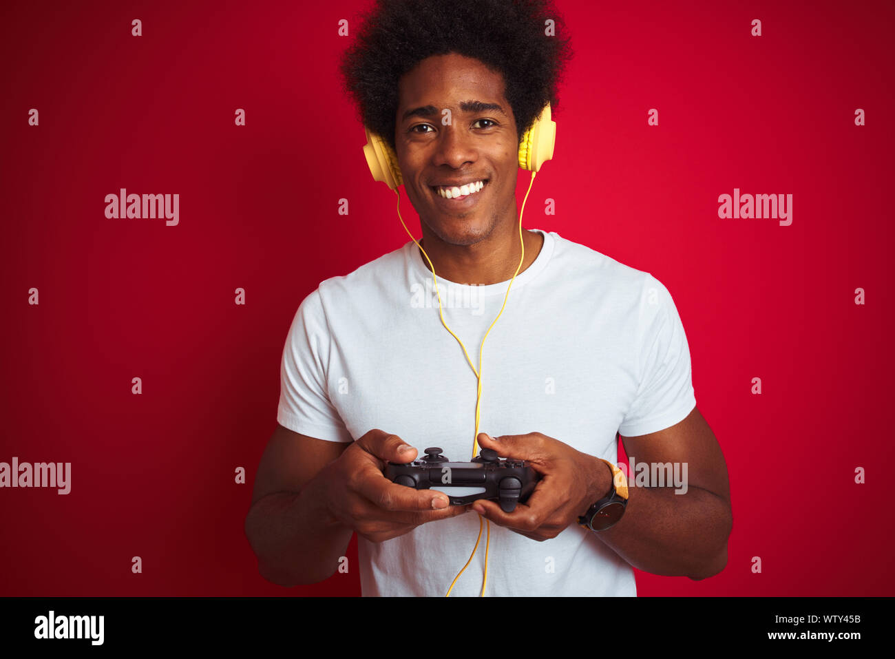 Afro gamer man playing video game using joystick headphones over ...