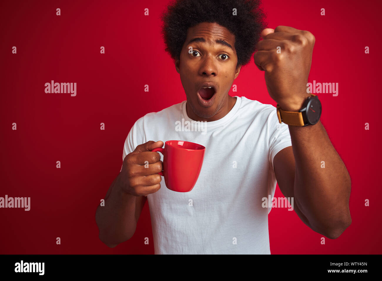 Young african american man drinking a cup of coffee standing over ...