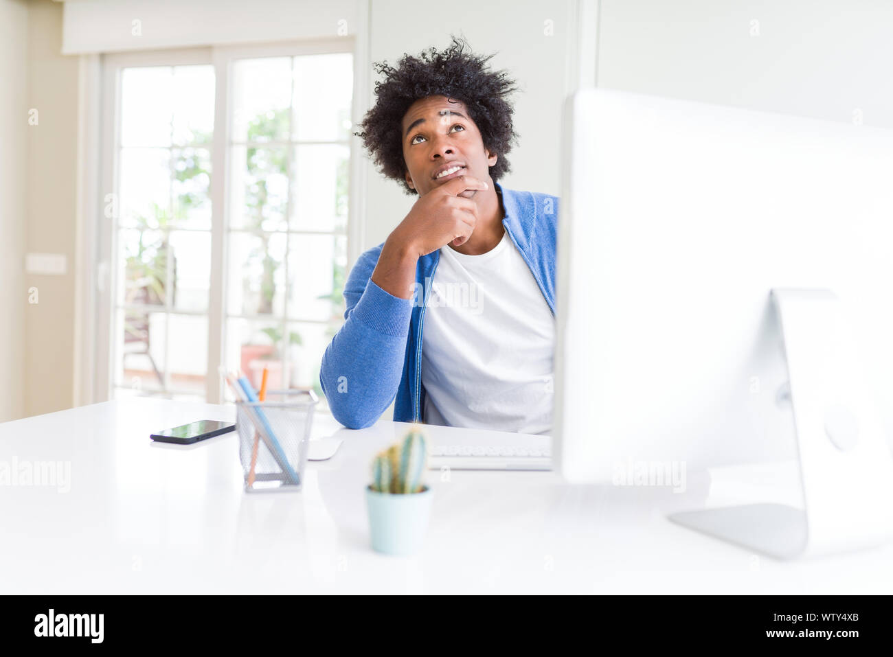 African American man working using computer serious face thinking about ...
