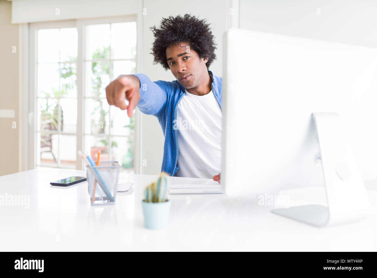 African American man working using computer pointing with finger to the ...