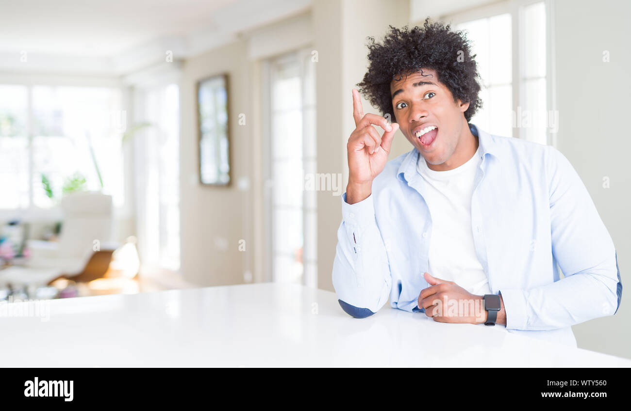 African American man at home pointing finger up with successful idea ...