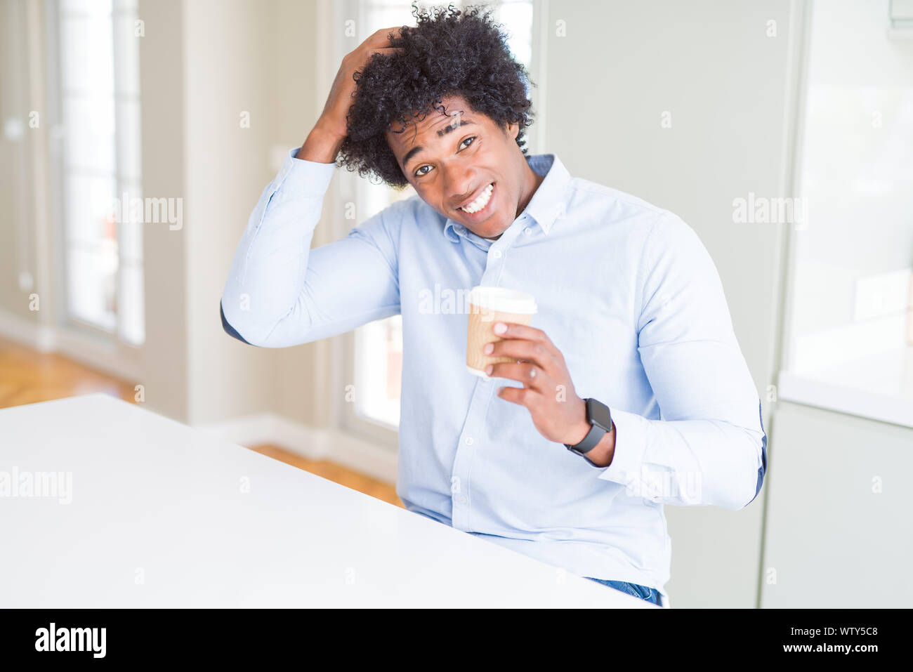 African American man with afro hair drinking a take away cup of coffee ...
