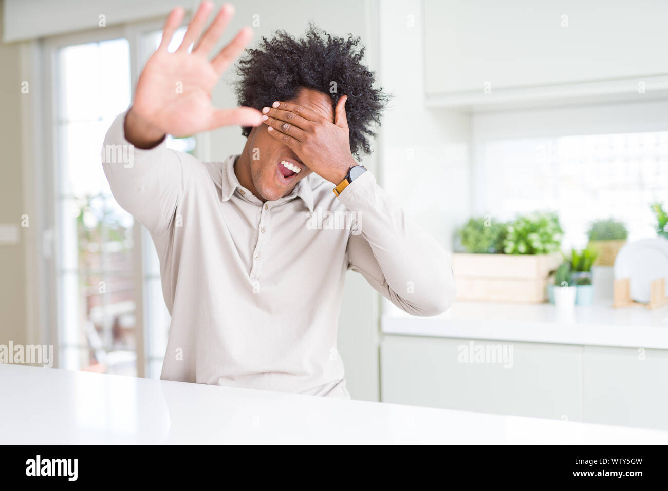 African American man at home covering eyes with hands and doing stop ...