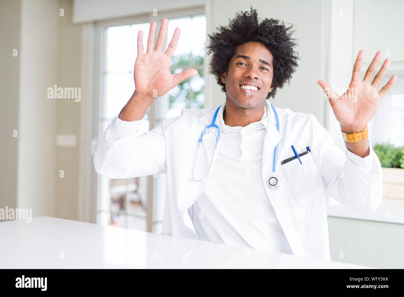 African American doctor man at the clinic showing and pointing up with ...