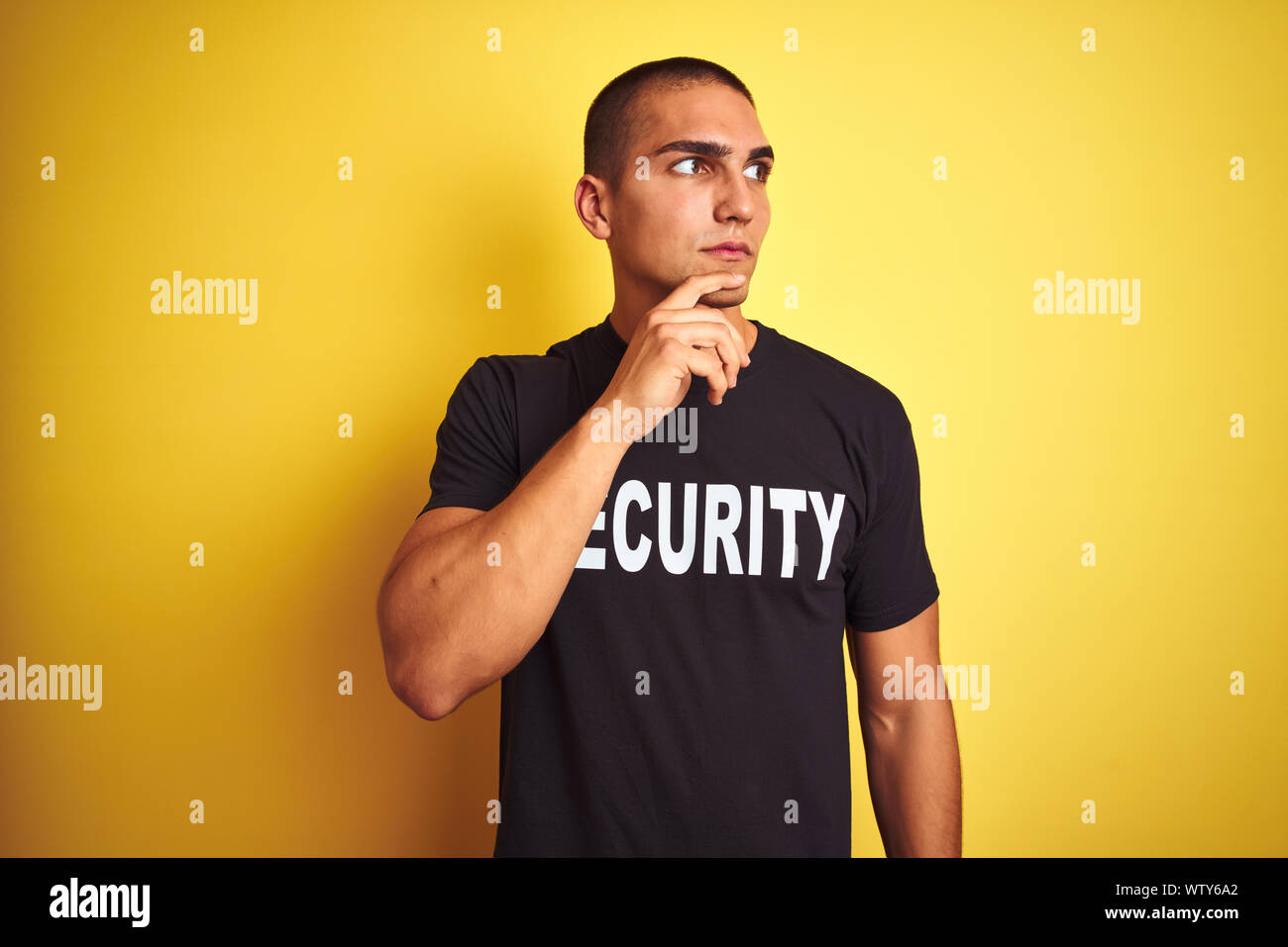 Young safeguard man with security t-shirt over yellow isolated ...