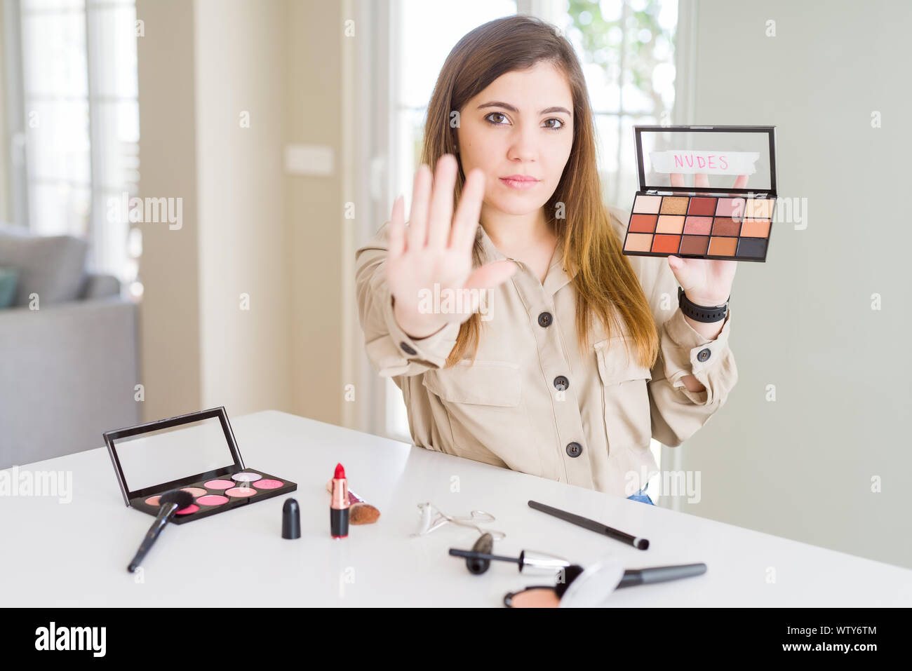Beautiful young woman using make up cosmetics applying color from ...
