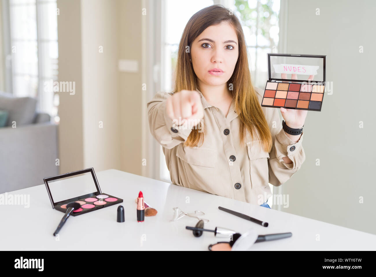 Beautiful young woman using make up cosmetics applying color from ...