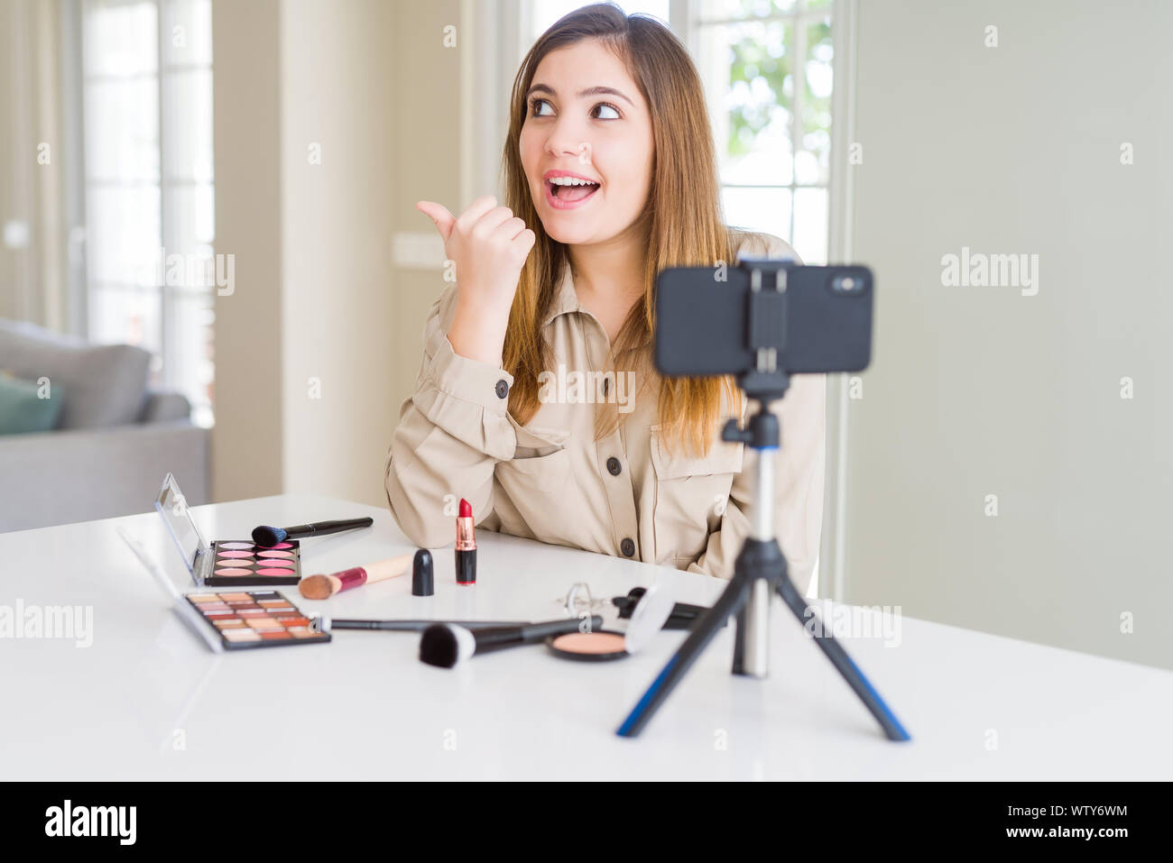 Beautiful young influencer woman recording make up video tutorial ...