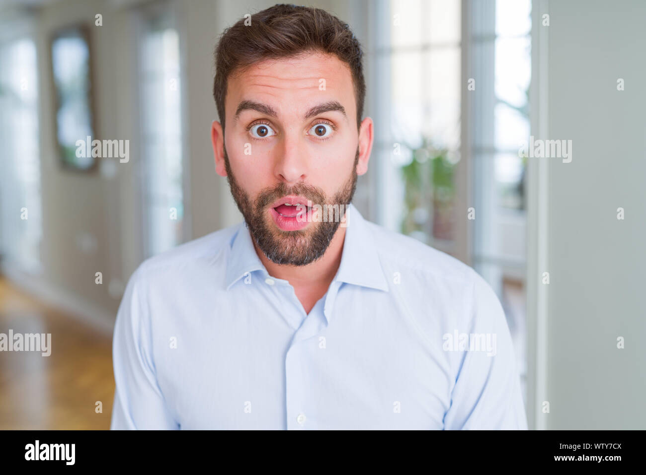 Handsome business man afraid and shocked with surprise expression, fear ...