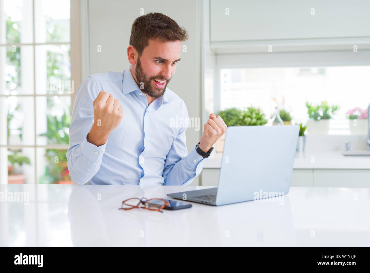 Handsome business man working using computer laptop screaming proud and ...