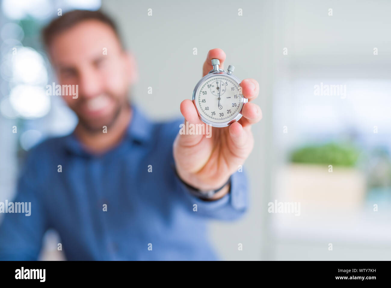Handsome man showing stopwatch Stock Photo - Alamy