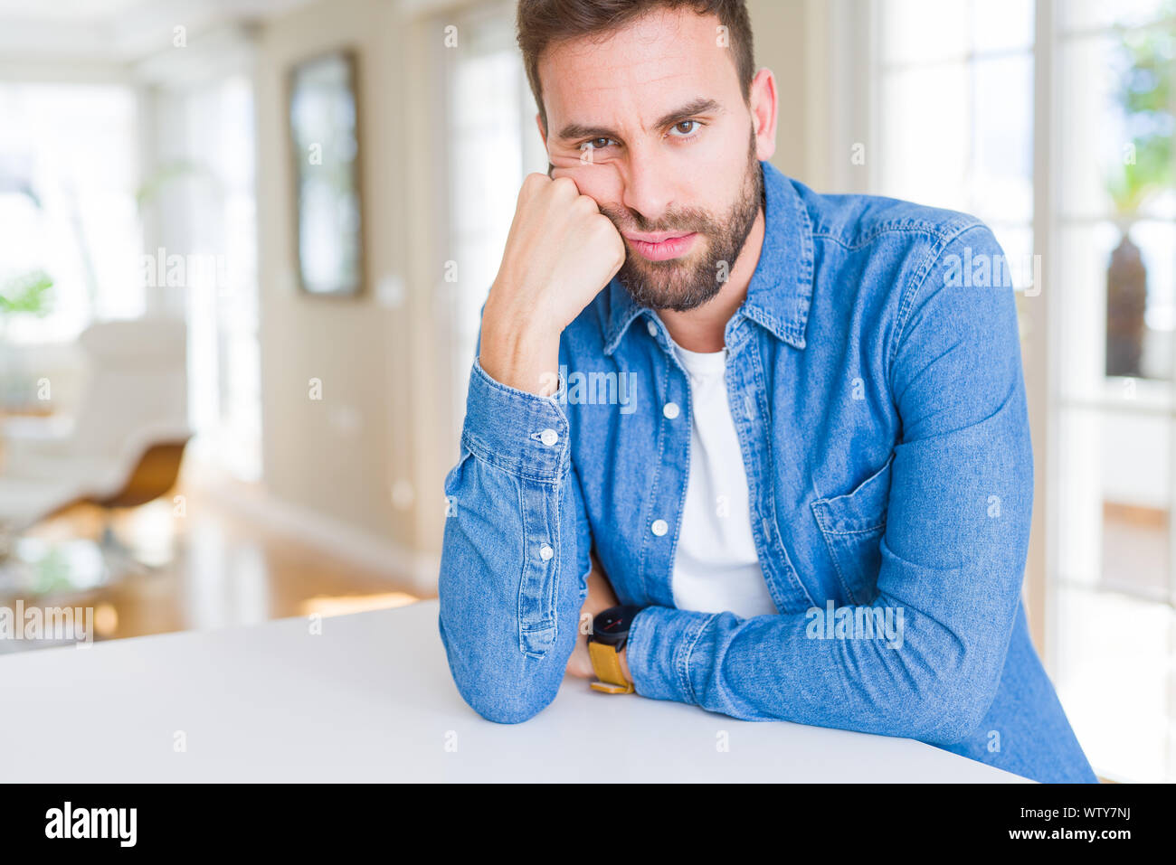 Handsome man at home thinking looking tired and bored with depression ...