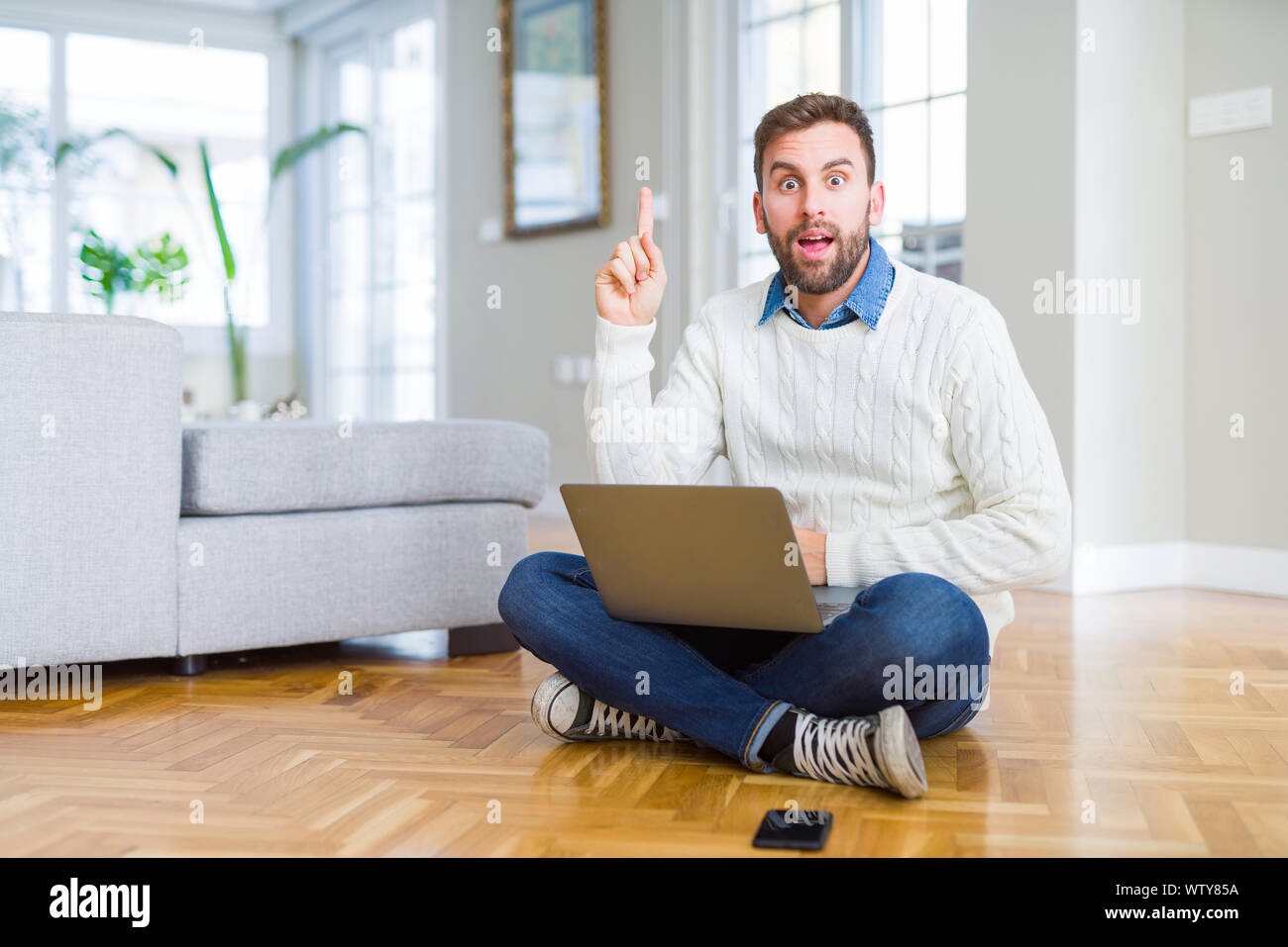 Handsome man wearing working using computer laptop pointing finger up ...