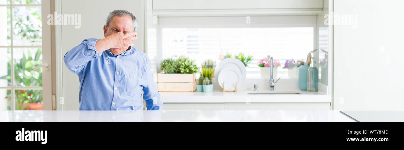 Wide angle perspective of handsome senior man at home smelling ...