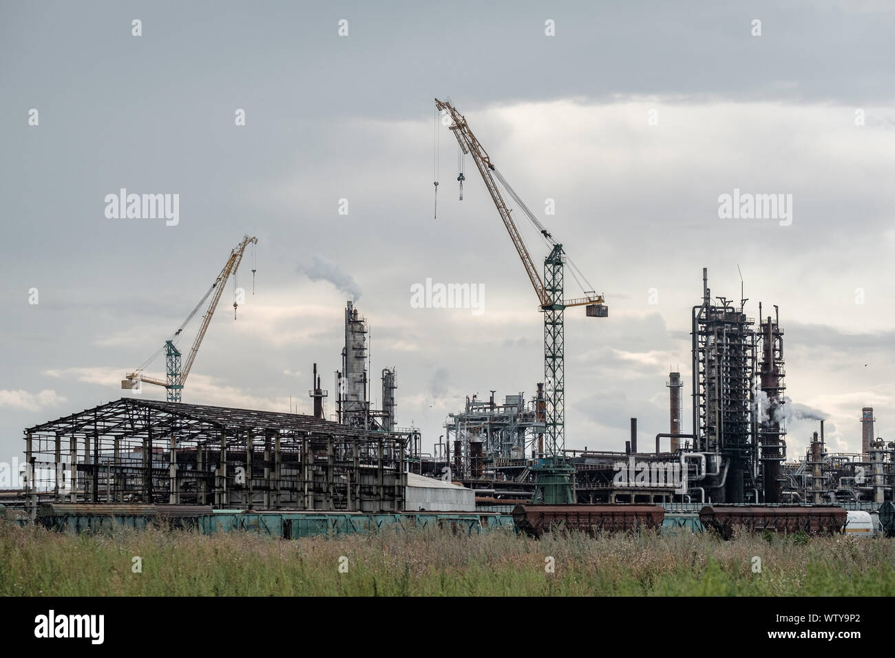 View of a complex of industrial buildings with smoking chimneys and ...