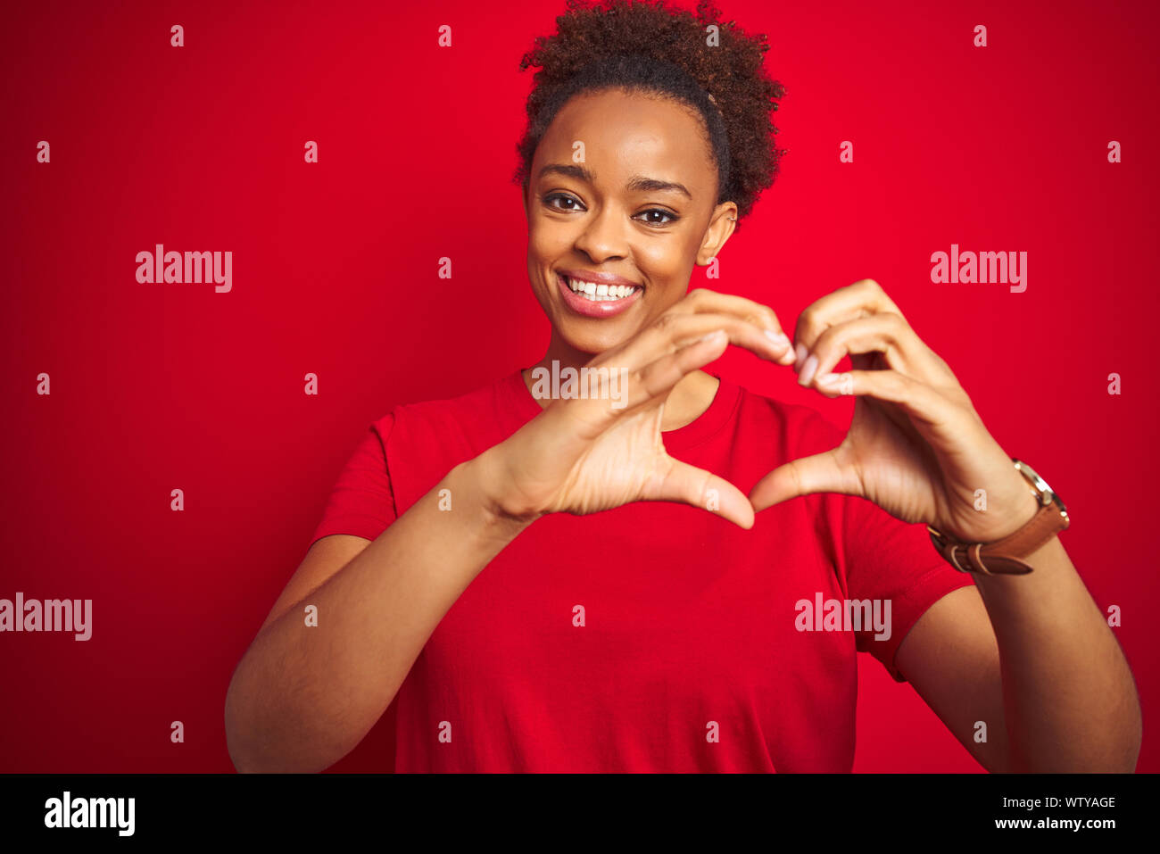 Young beautiful african american woman with afro hair over isolated red ...