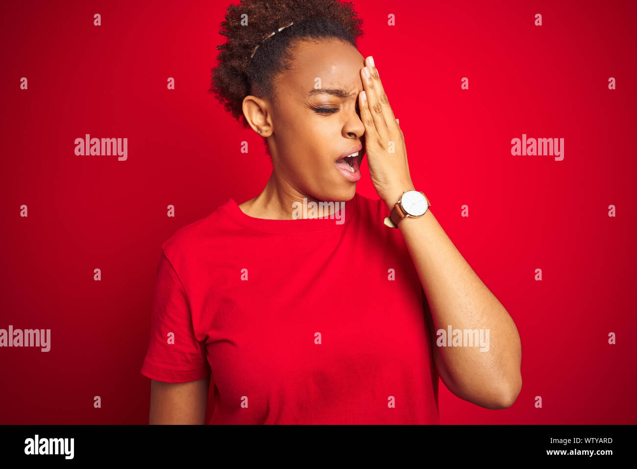 Young beautiful african american woman with afro hair over isolated red ...
