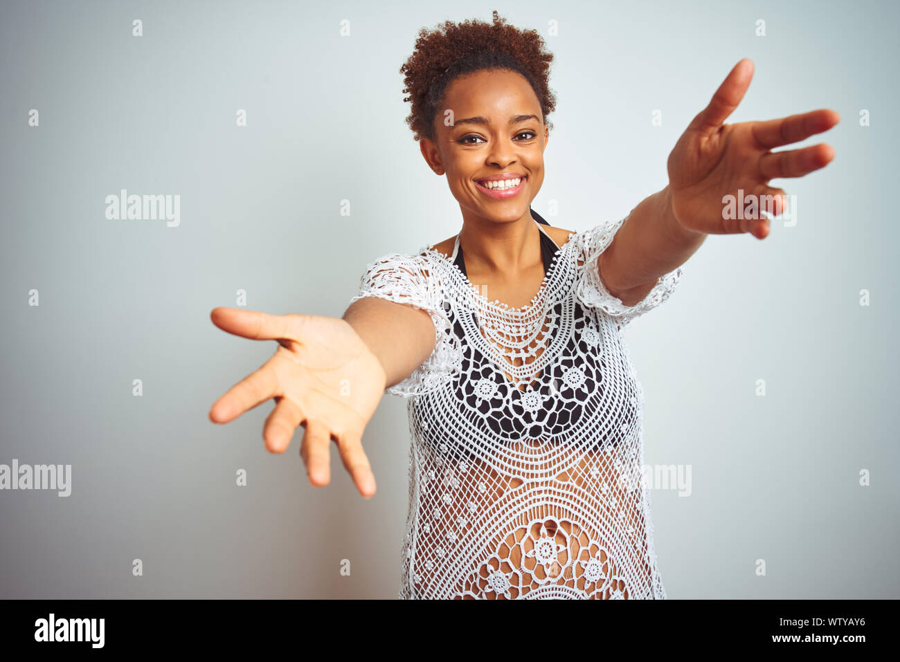 Young african american woman with afro hair wearing a bikini over white ...