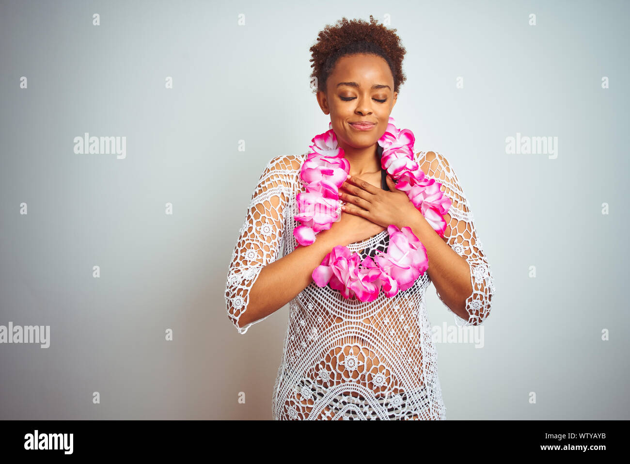 Young african american woman with afro hair wearing flower hawaiian lei ...