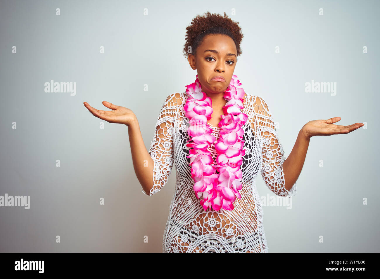 Young african american woman with afro hair wearing flower hawaiian lei ...
