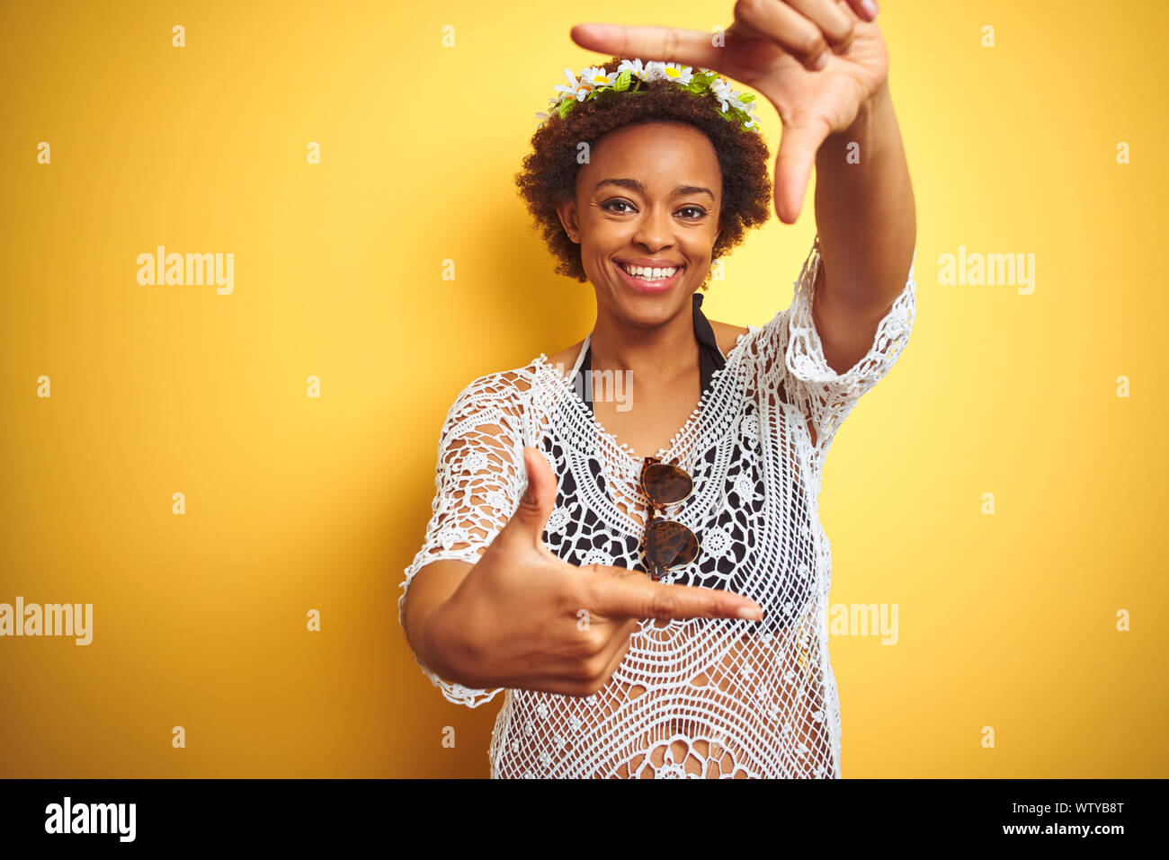 Young african american woman with afro hair wearing flowers crown over ...