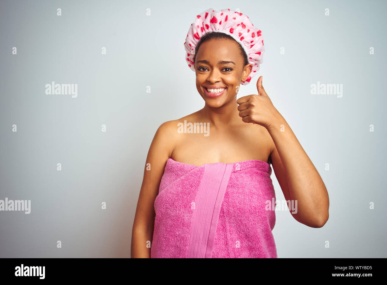 African american woman wearing pink shower towel after bath over ...