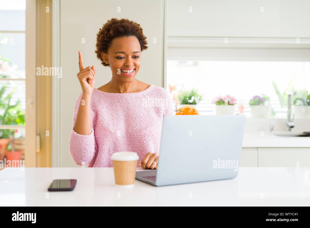 Young african american woman working using computer laptop pointing ...