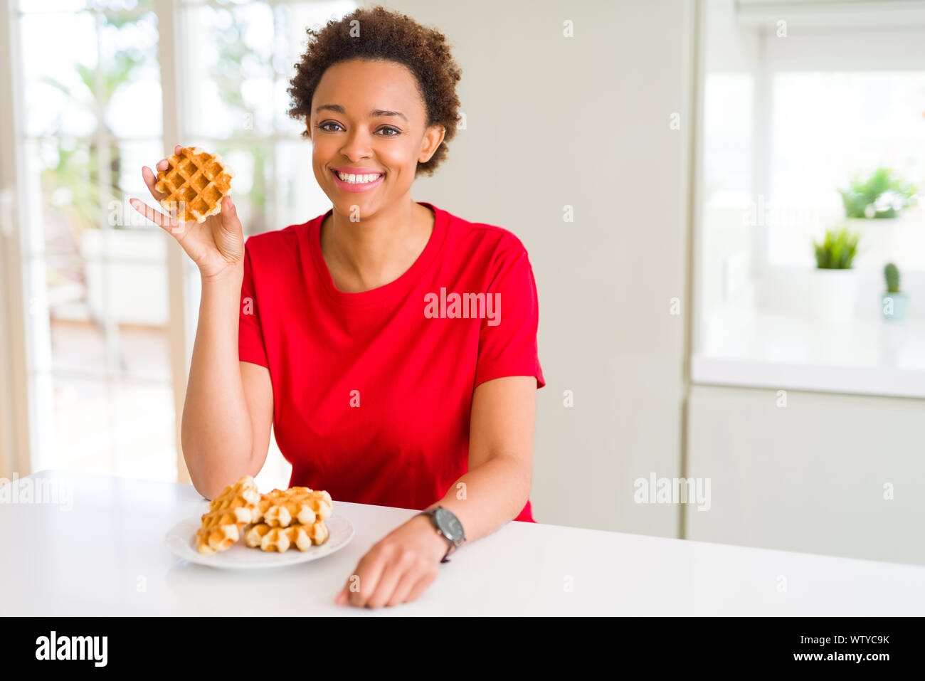 Young african american woman eating sweet waffle with a happy face ...