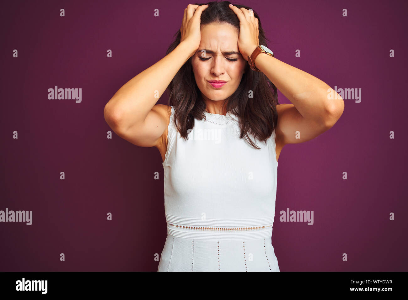 Young beautiful woman wearing white dress standing over purple isolated ...