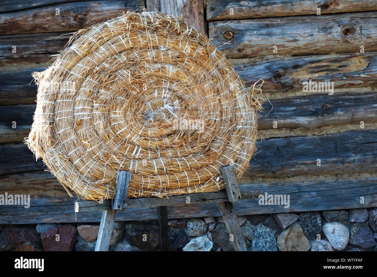 traditional straw target for archery standing in front of wooden wall ...