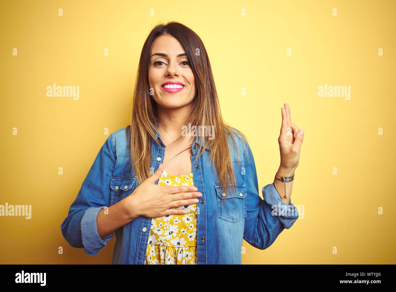 Young beautiful woman standing over yellow isolated background smiling ...