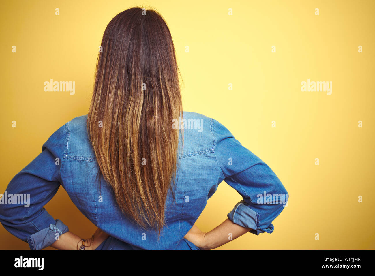 Young beautiful woman standing over yellow isolated background standing ...
