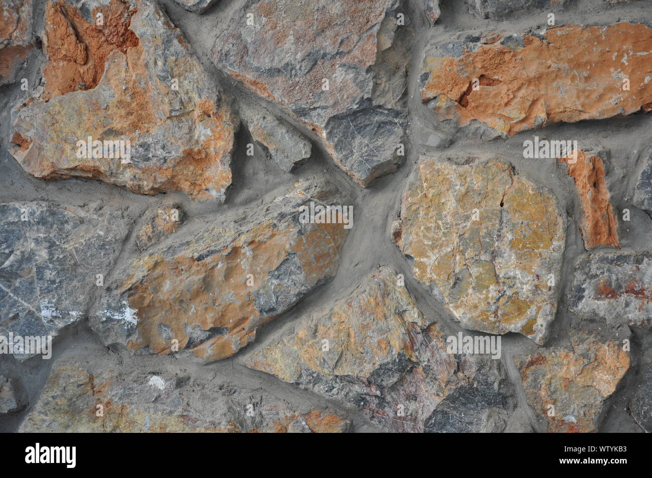 Wall made of natural stone with a red tint. Texture, background Stock ...