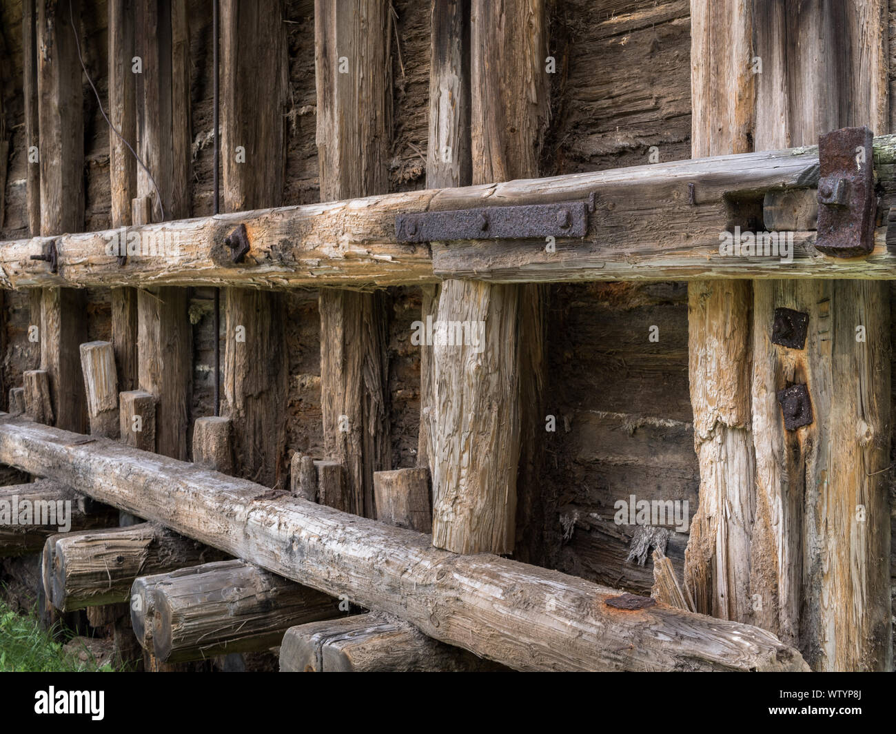 Elements of an ancient structure made of wooden logs and steel bolts ...