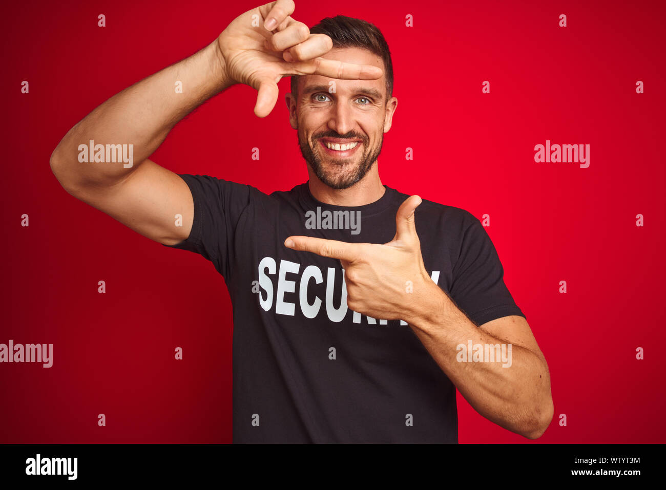 Young safeguard man wearing security uniform over red isolated ...