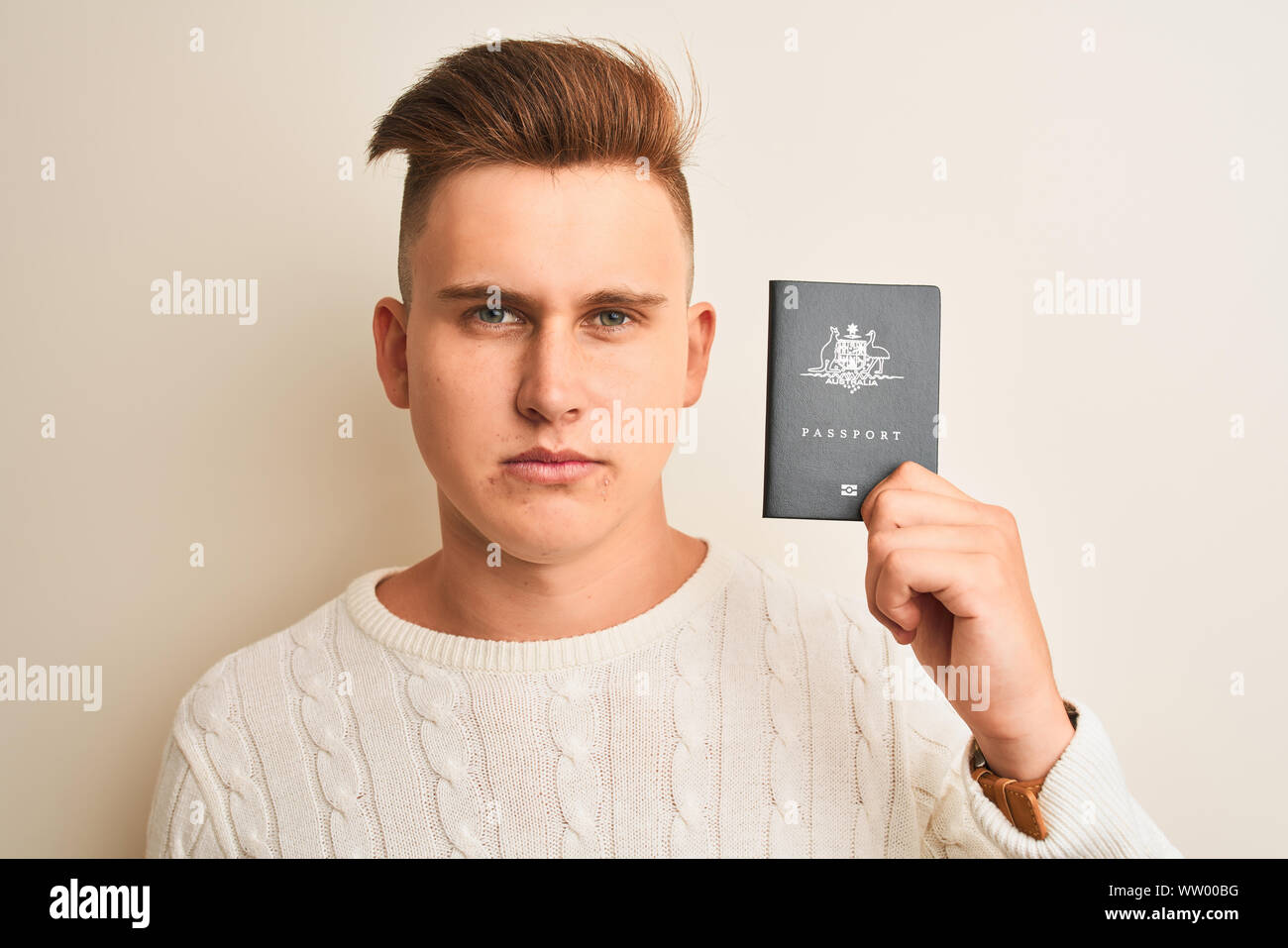 Young handsome man holding Australia Australian passport over isolated ...