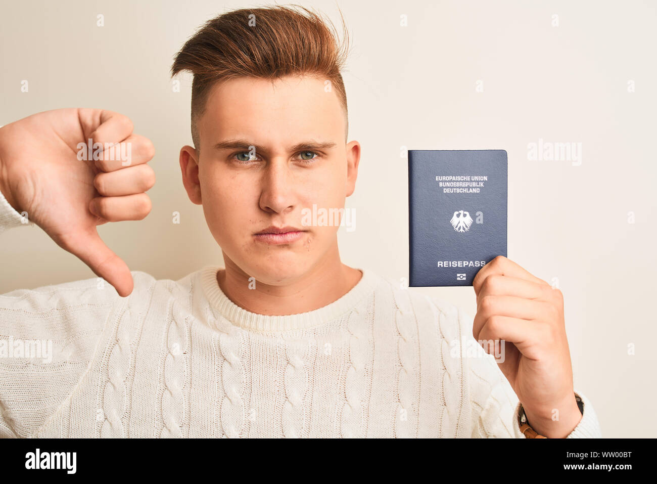 Young handsome man holding Germany German passport over isolated white ...