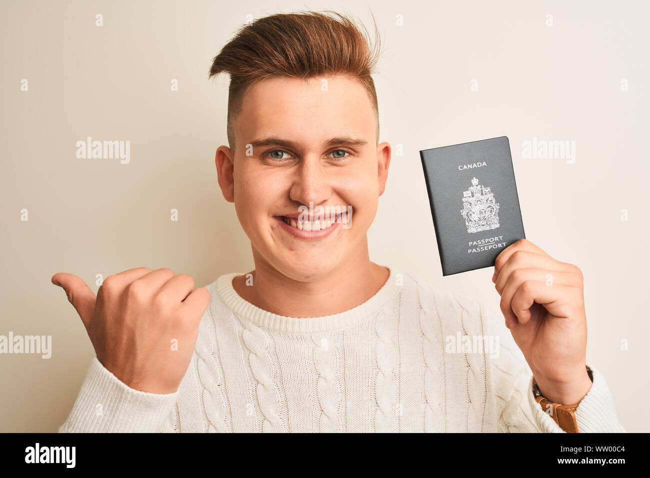 Young handsome man holding Canada Canadian passport over isolated white ...