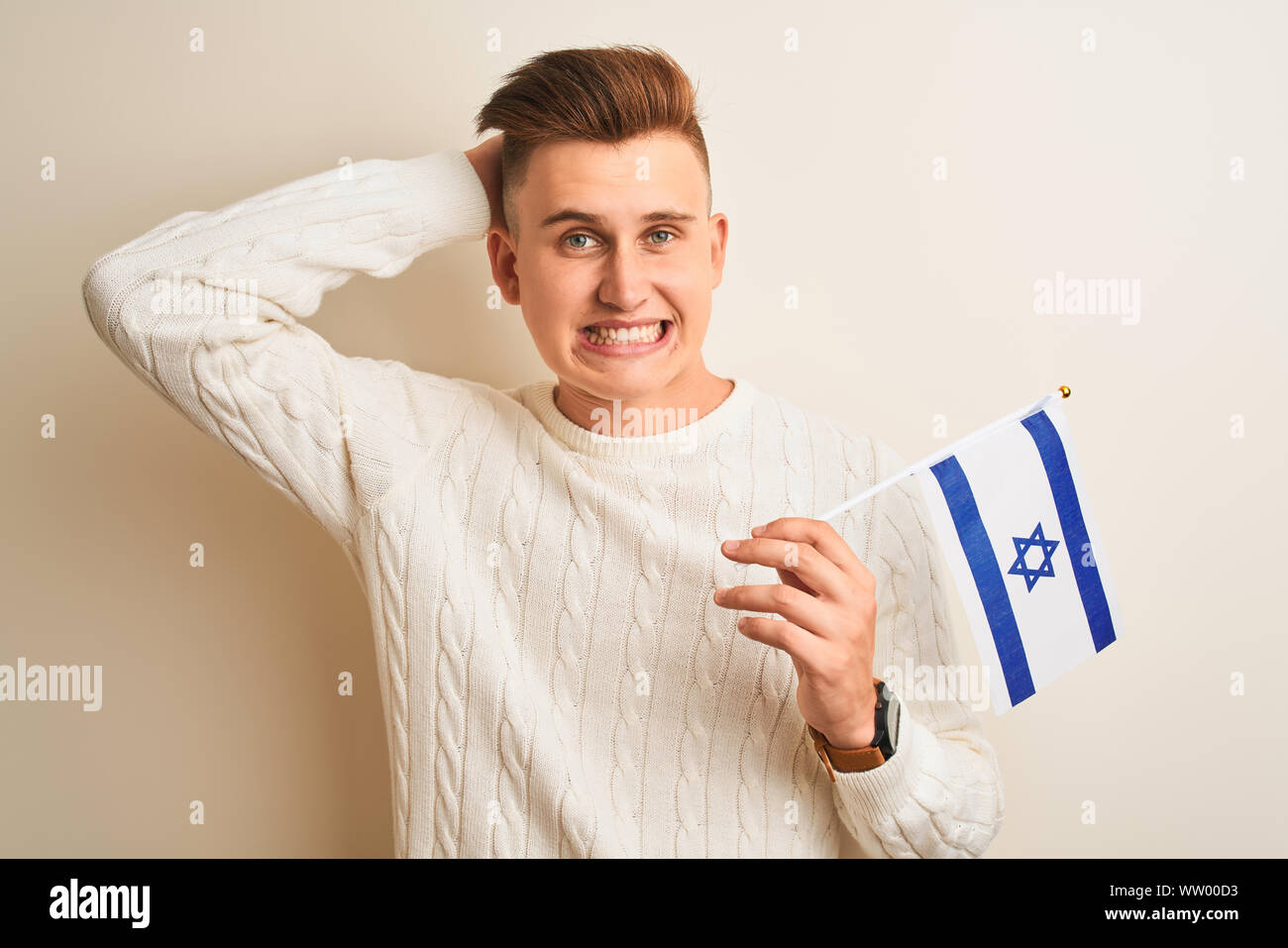 Young handsome man holding Israel Israeli flag over isolated white ...