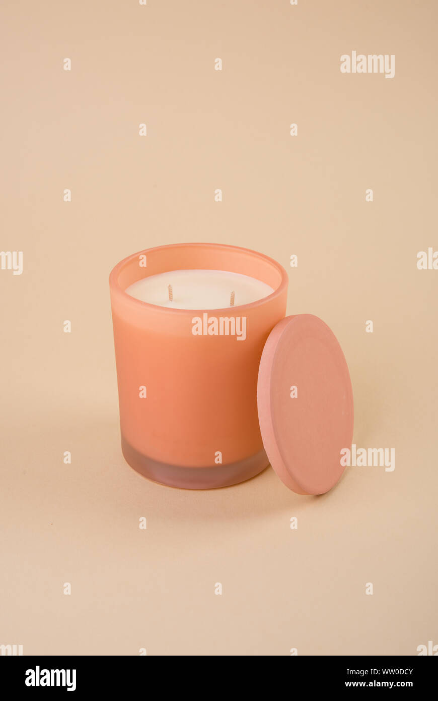 Candle in orange glass with lid studio shot mock-up with copy space ...