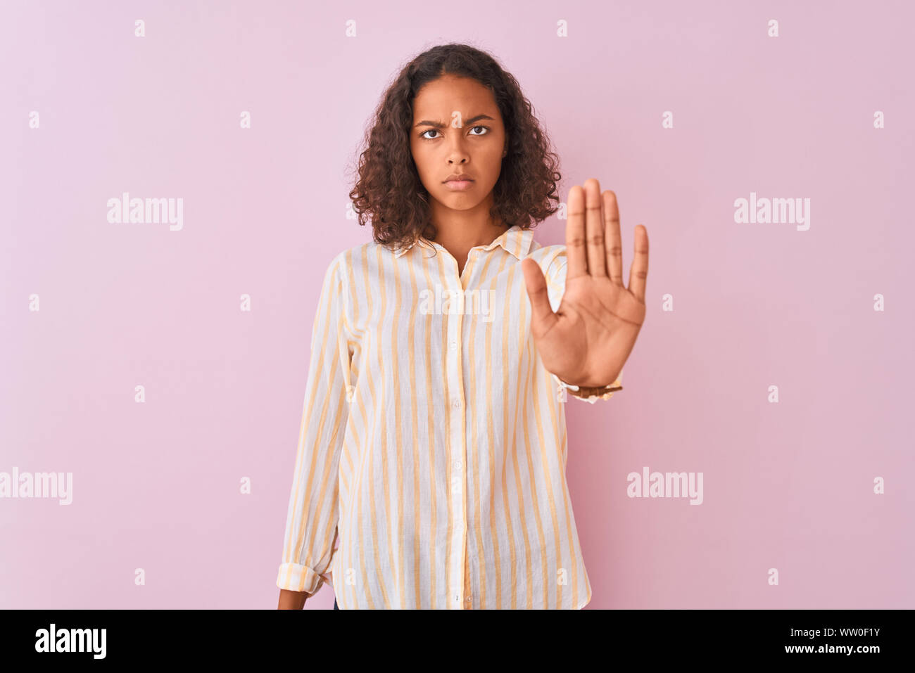 Young Brazilian Woman Wearing Striped Shirt Standing Over Isolated Pink