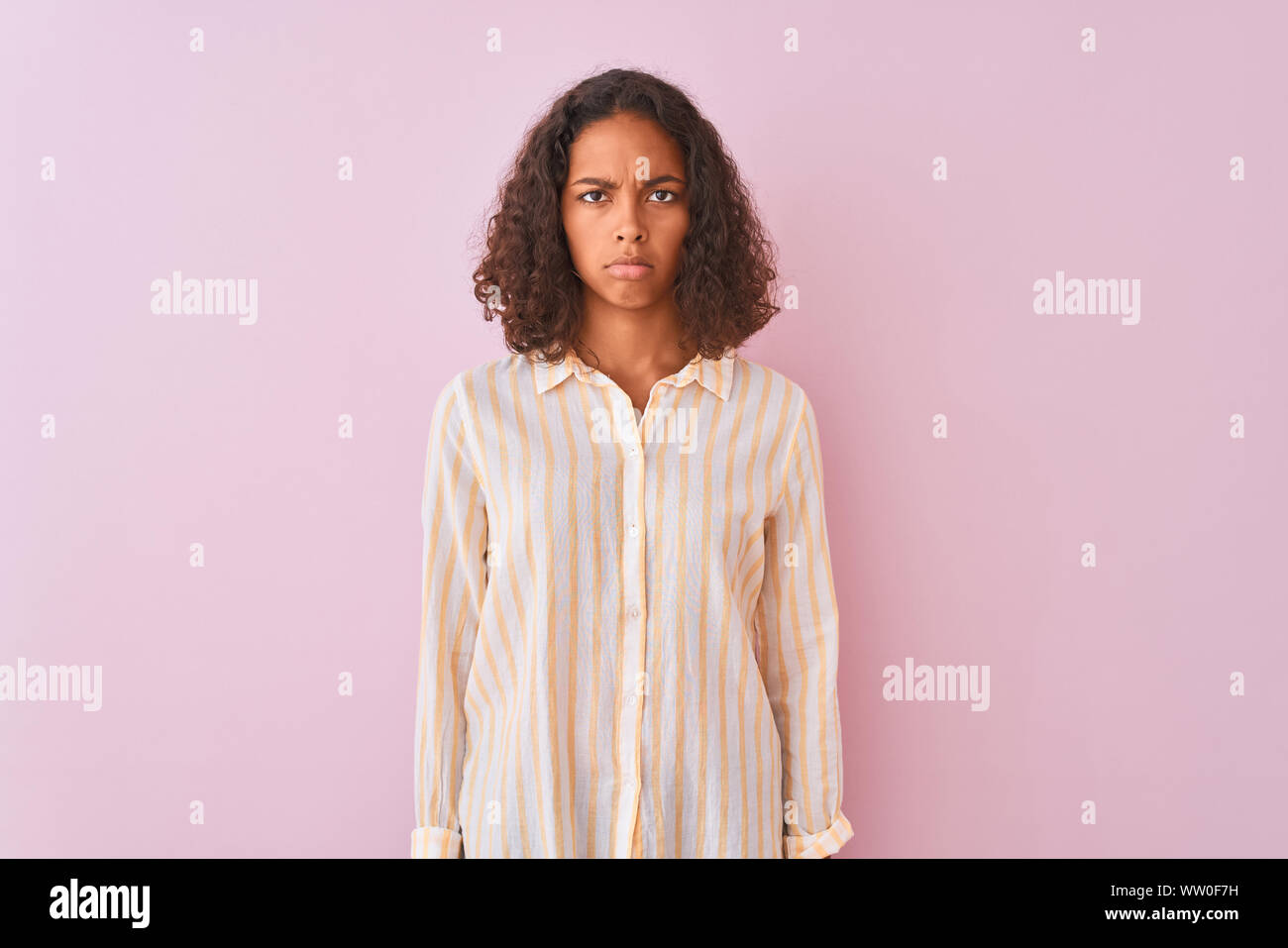 Young Brazilian Woman Wearing Striped Shirt Standing Over Isolated Pink