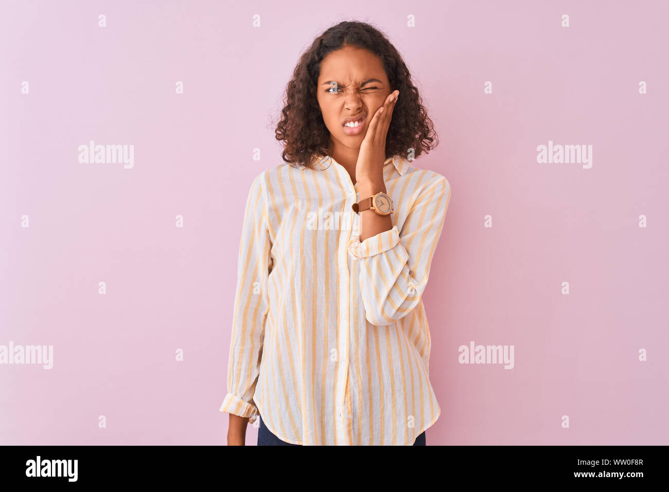 Young Brazilian Woman Wearing Striped Shirt Standing Over Isolated Pink