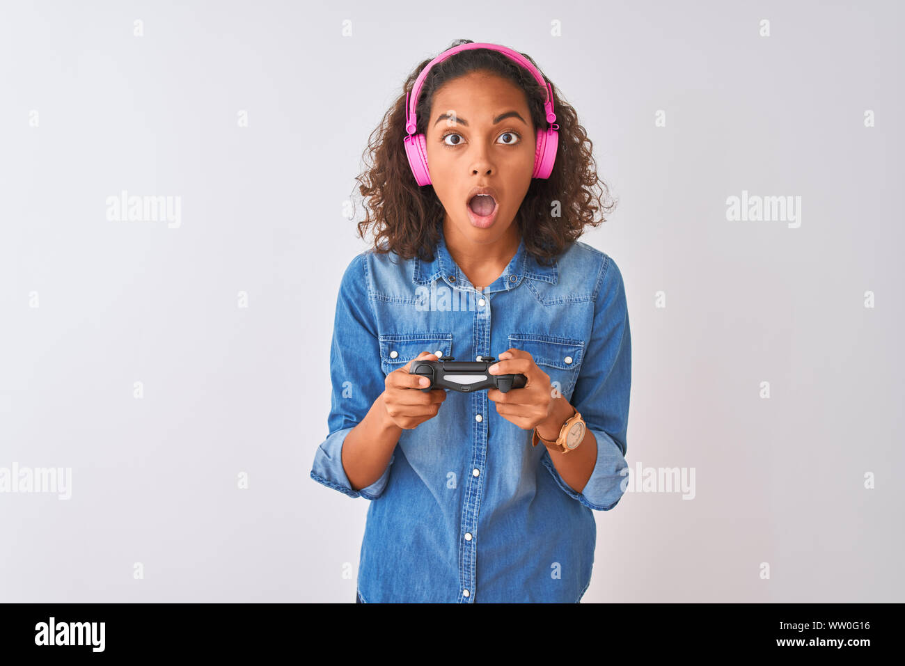 Brazilian gamer woman playing video game using headphones over isolated ...