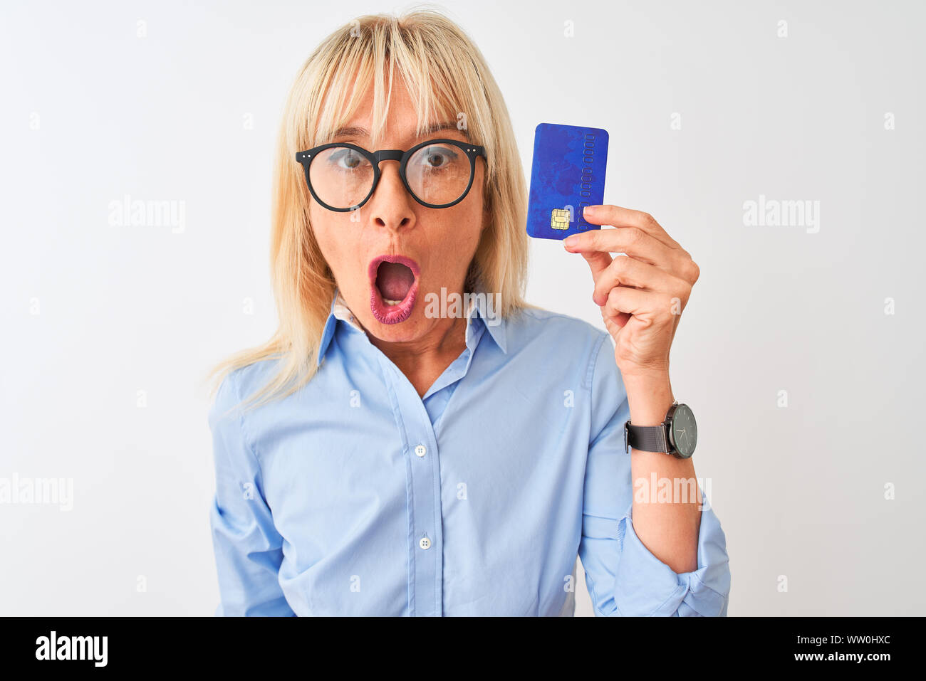 Middle age businesswoman wearing glasses holding credit card over ...